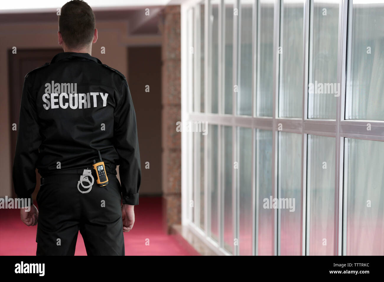 Security man standing back in corridor Stock Photo - Alamy
