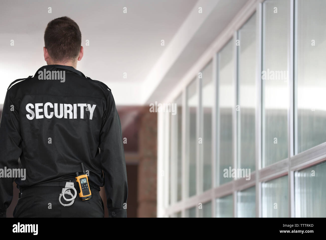 Security man standing back in corridor Stock Photo - Alamy