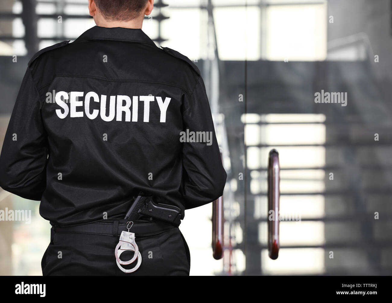 Security man standing back beside stairs Stock Photo - Alamy