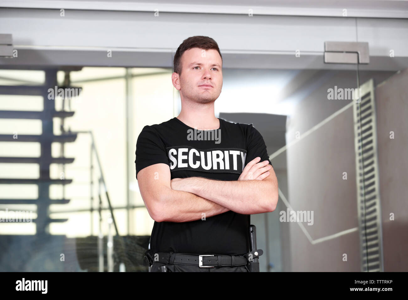 Security man standing beside stairs Stock Photo - Alamy