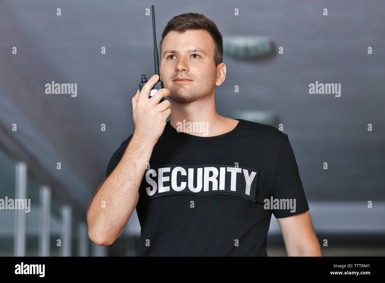 Security man in corridor using portable radio Stock Photo - Alamy