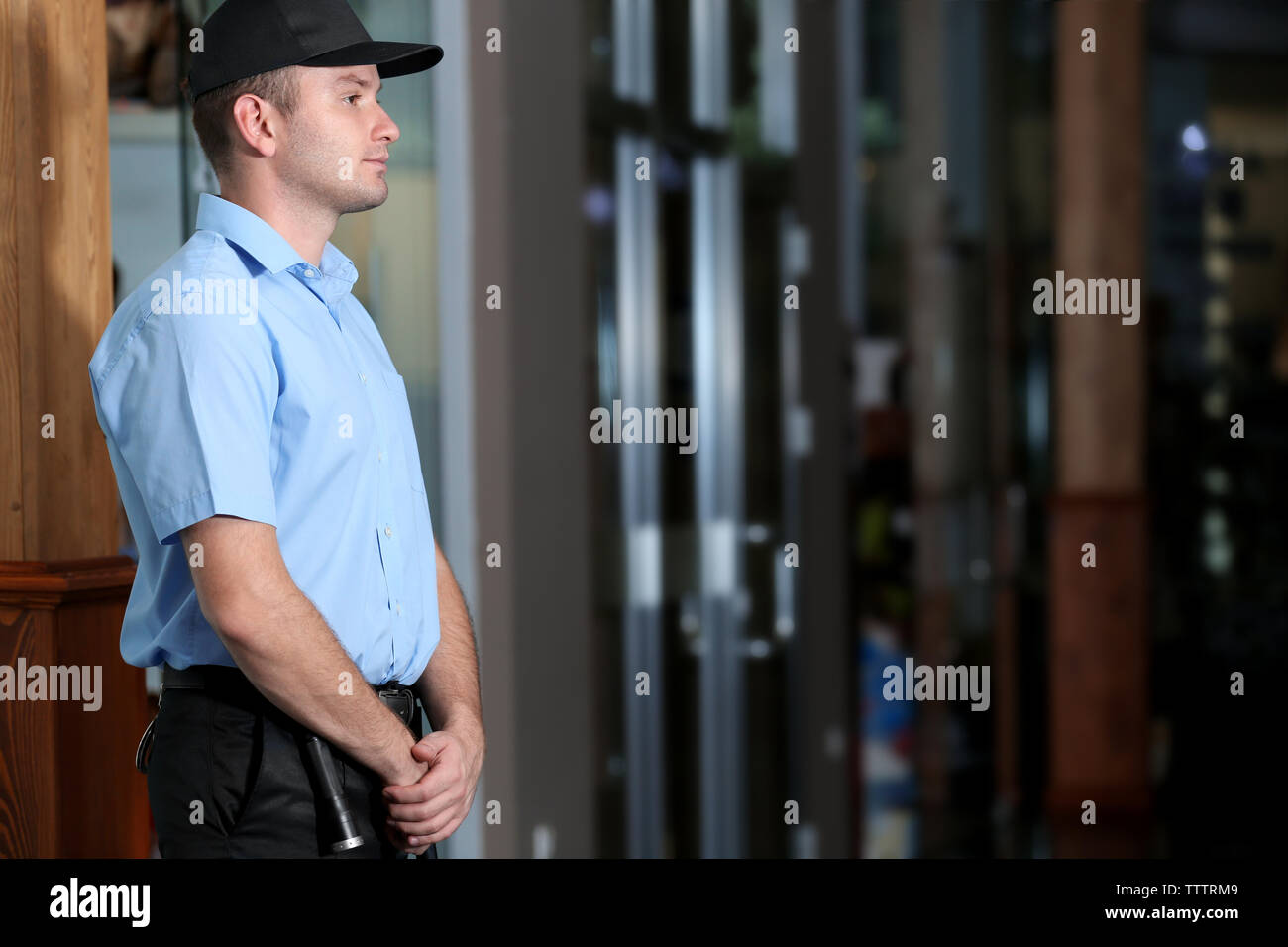 Security man standing indoors Stock Photo - Alamy