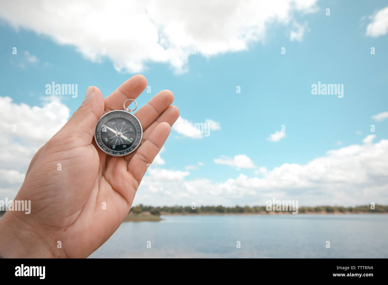 Male hands holding a compass on the sky background Stock Photo - Alamy