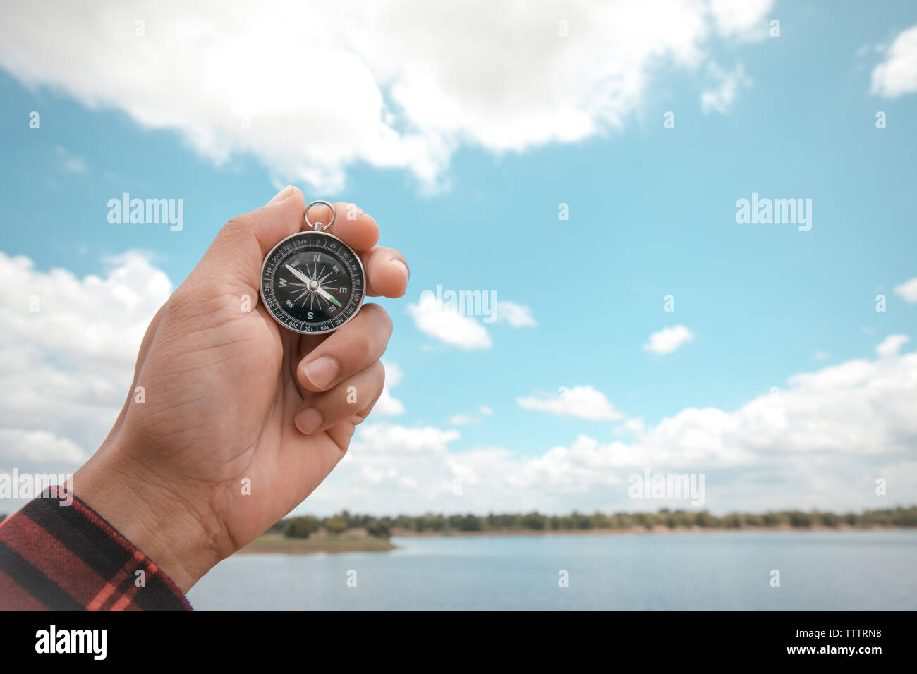 Male hands holding a compass on the sky background Stock Photo - Alamy
