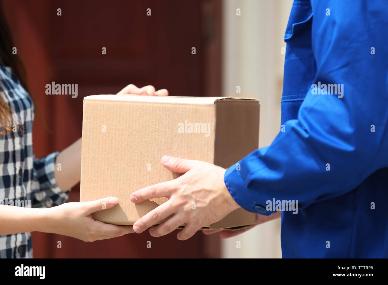 Male deliverer giving box to client Stock Photo - Alamy