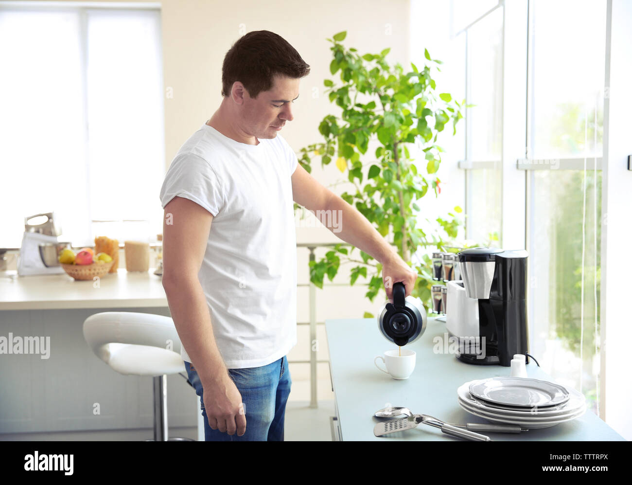 Handsome man making morning coffee in kitchen Stock Photo - Alamy