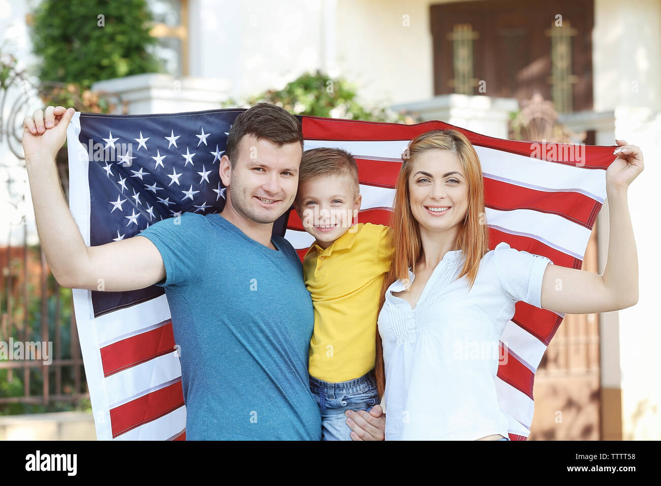 Happy family with American flag in the yard Stock Photo - Alamy