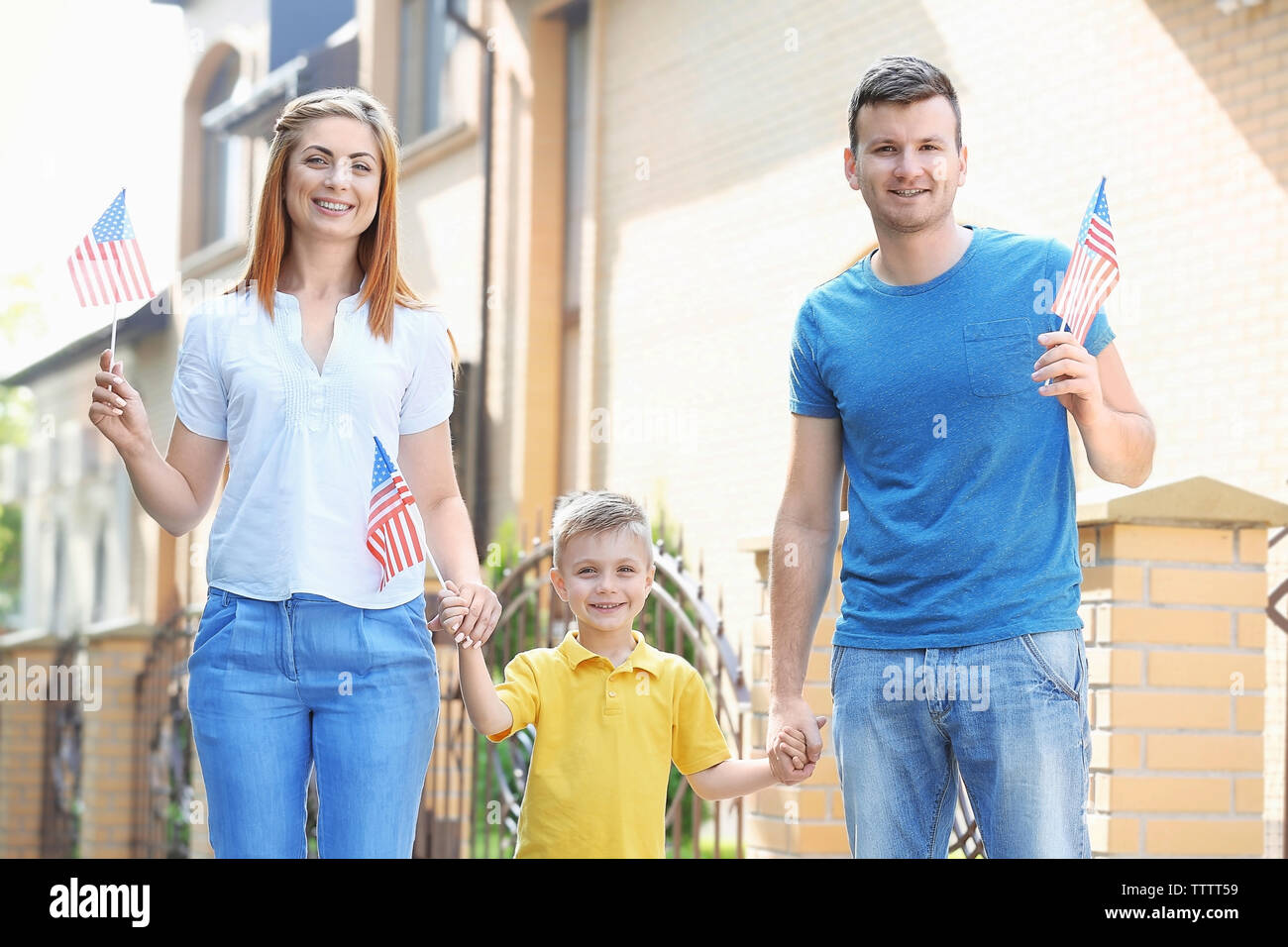 Happy family with little American flags in the yard Stock Photo - Alamy