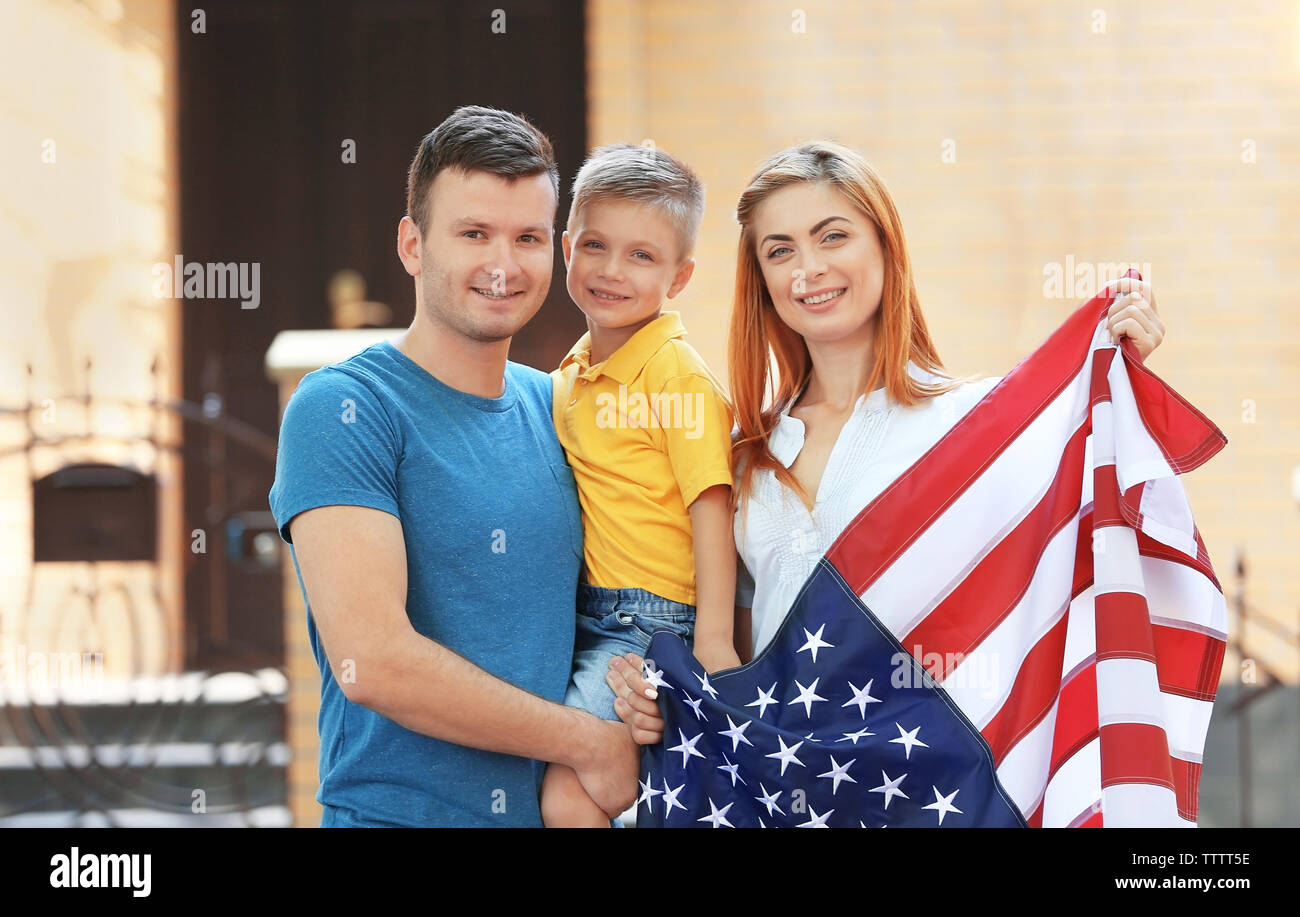 Happy family with American flag beside their house Stock Photo - Alamy