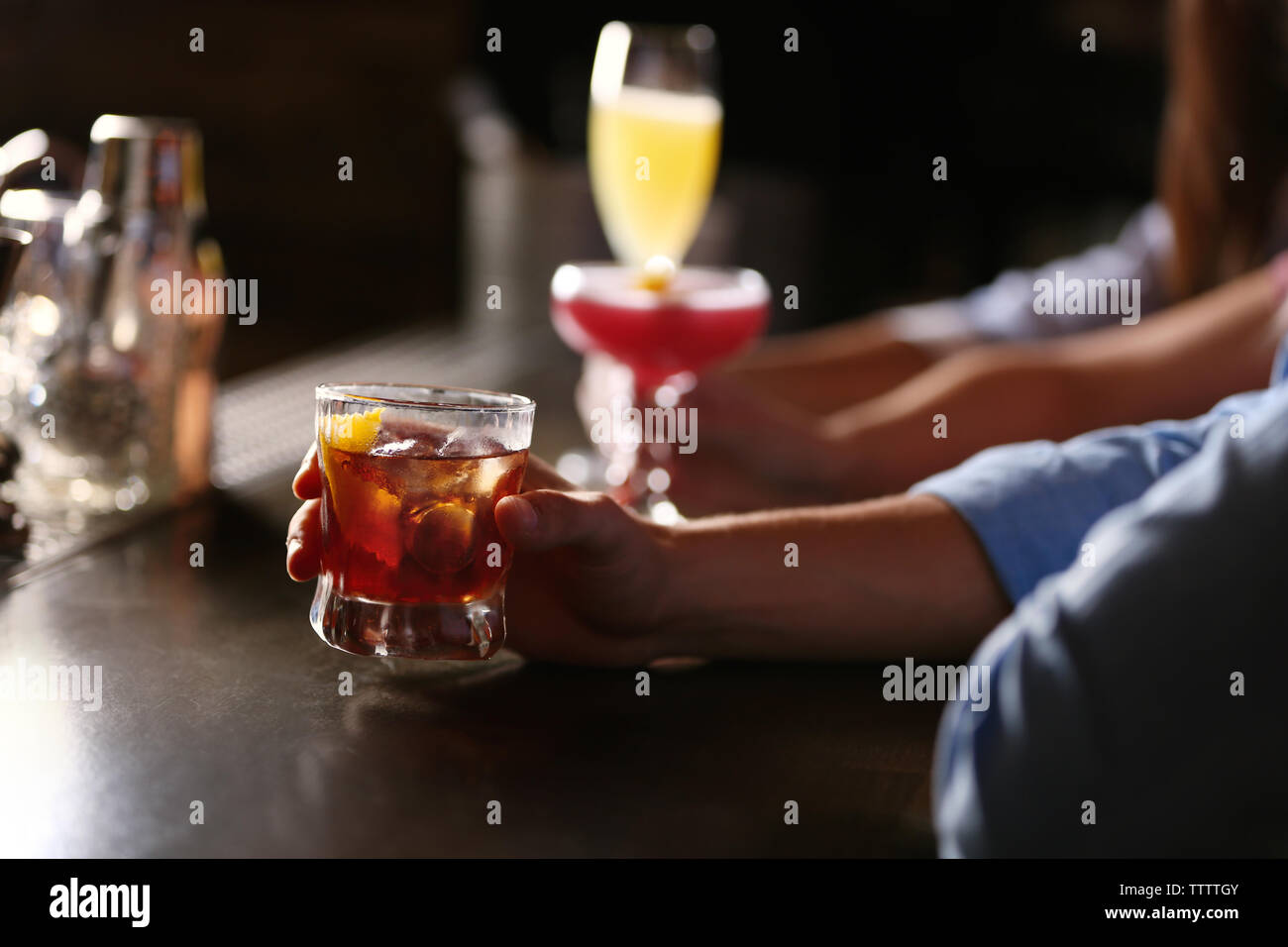 Man holding tasty long drink on bar counter Stock Photo - Alamy