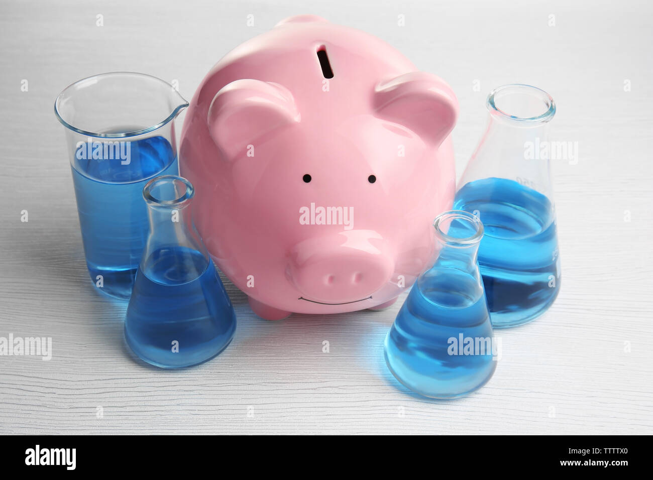 Pig money box and glass tubes with water on light background Stock ...
