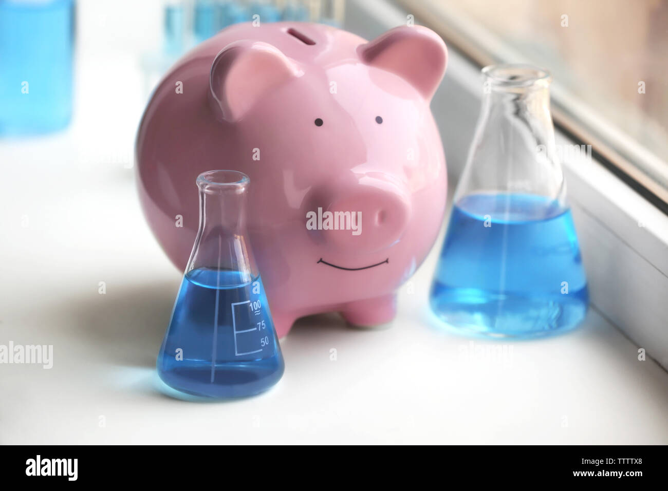 Pig money box and tubes with water on windowsill Stock Photo - Alamy