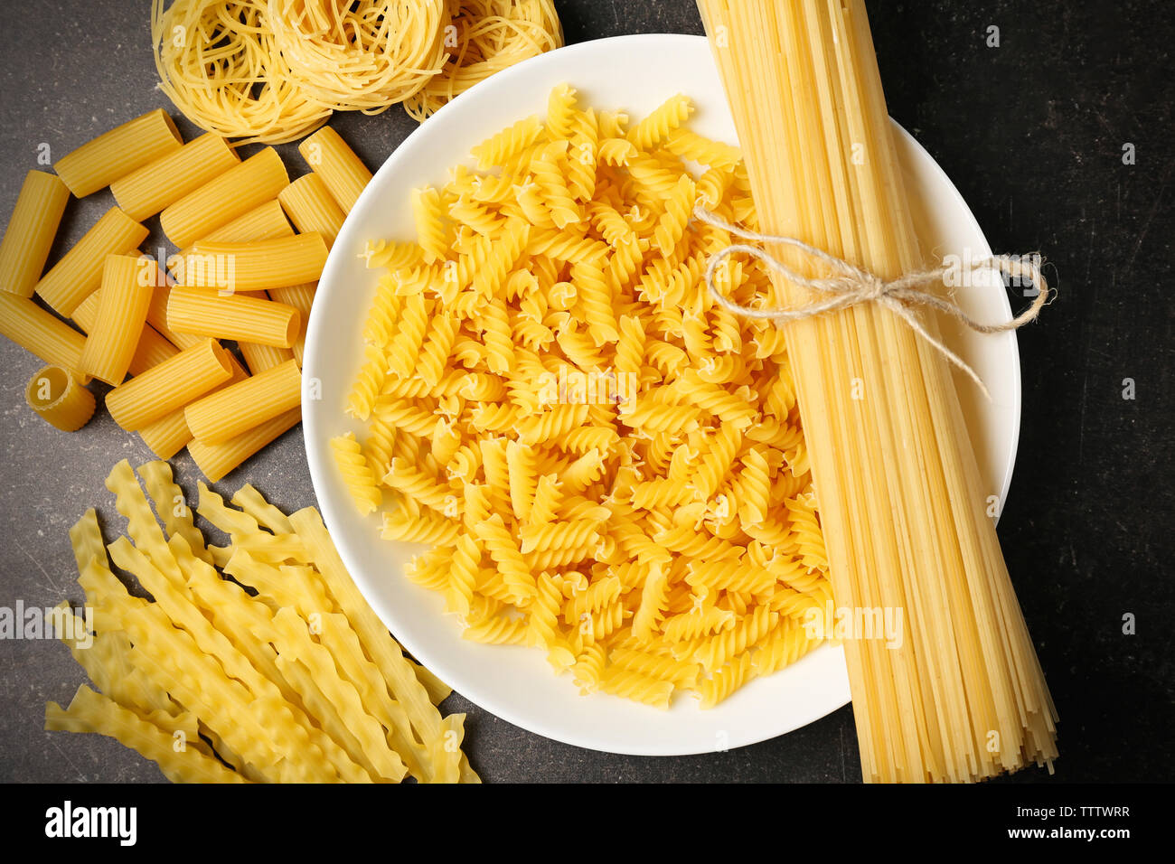 Plate with different kinds of dry pasta on table Stock Photo - Alamy