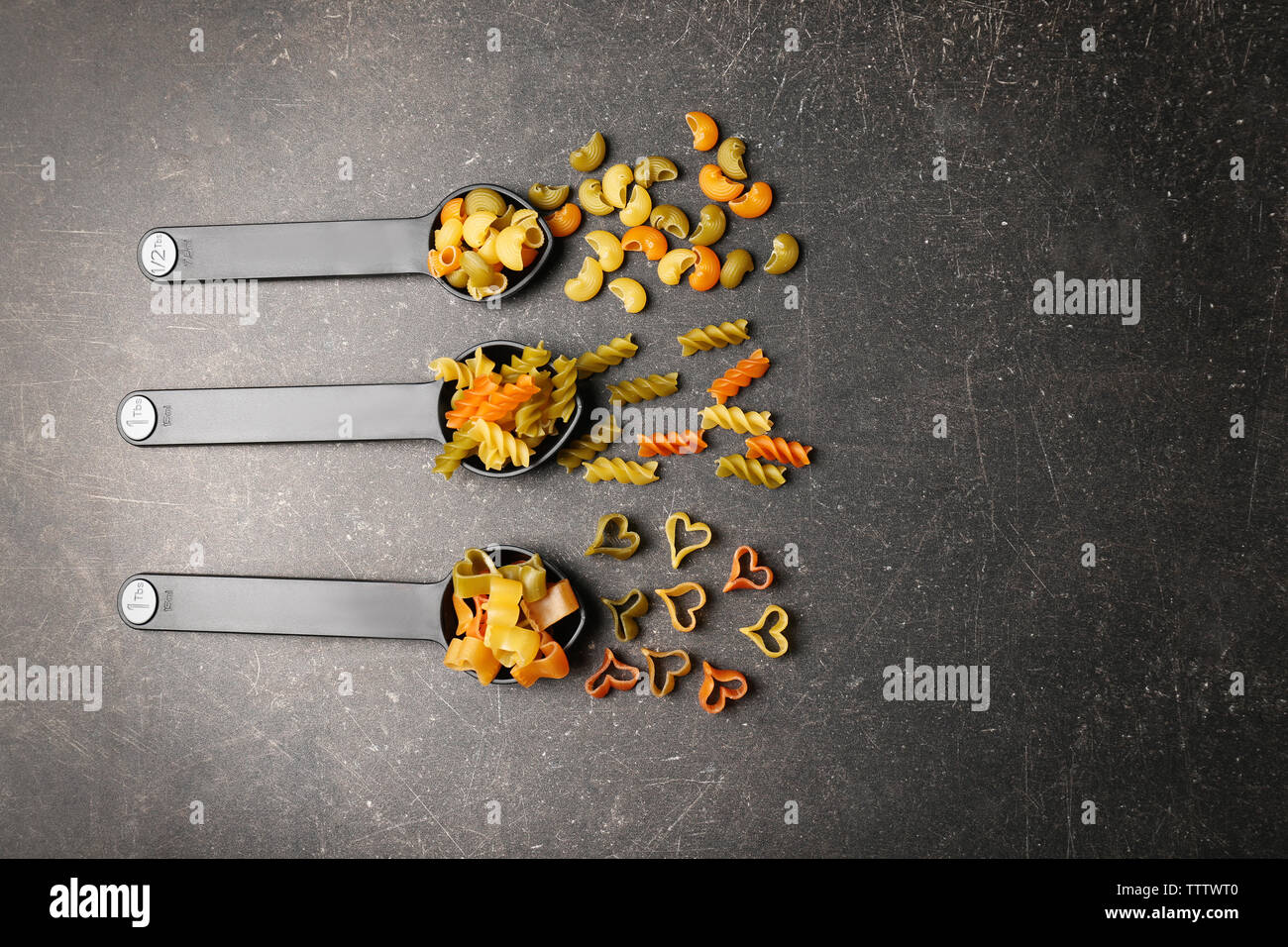 Different dry pasta on measuring spoons Stock Photo - Alamy