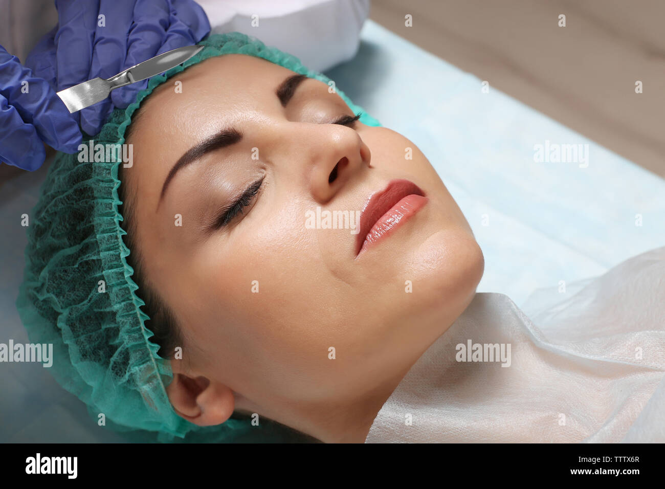 Surgeon hands with scalpel above female face Stock Photo - Alamy