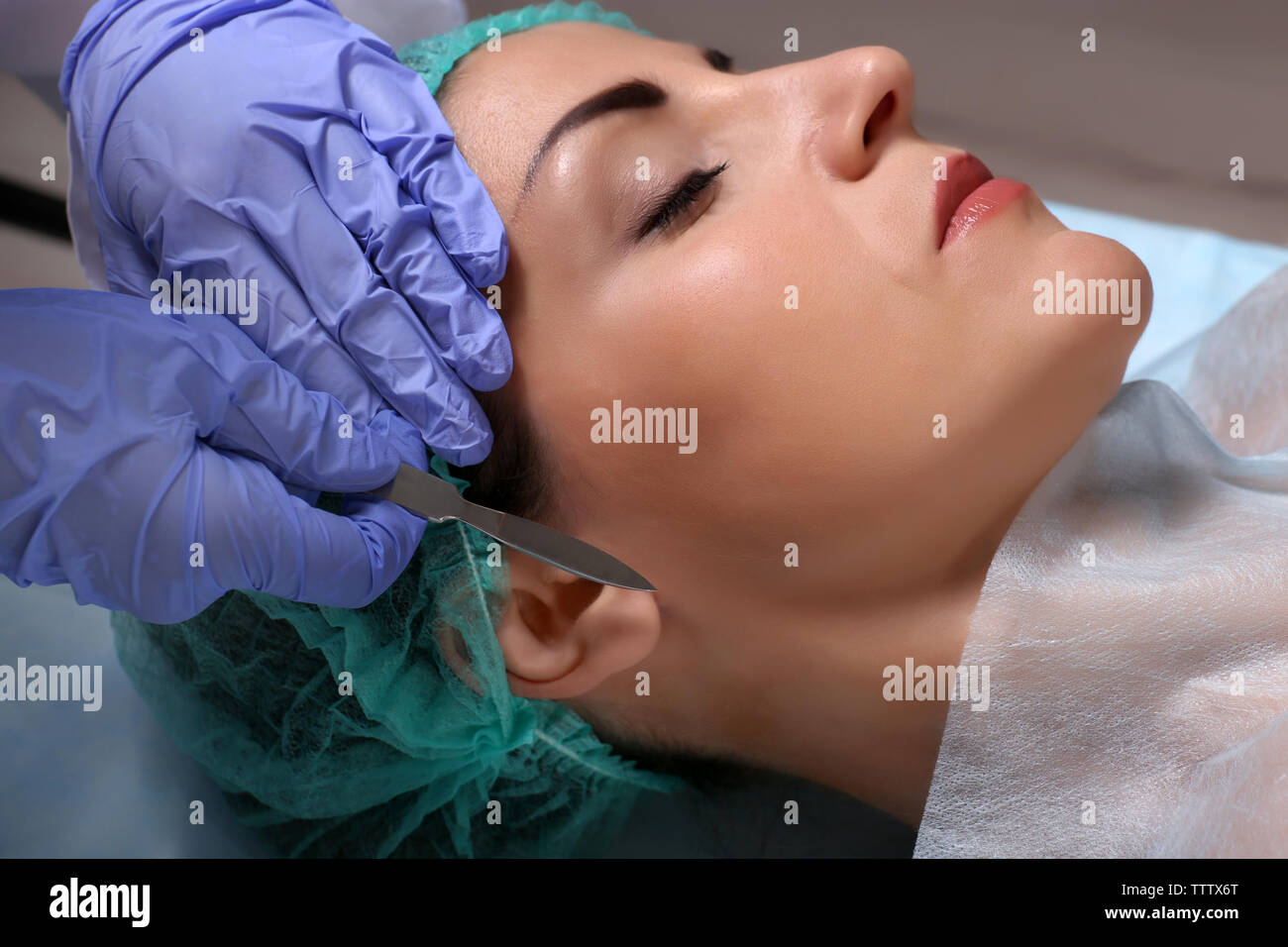Surgeon hands with scalpel above female face Stock Photo - Alamy