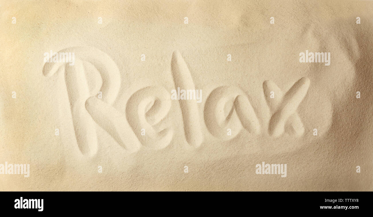 Word RELAX written on sand Stock Photo - Alamy