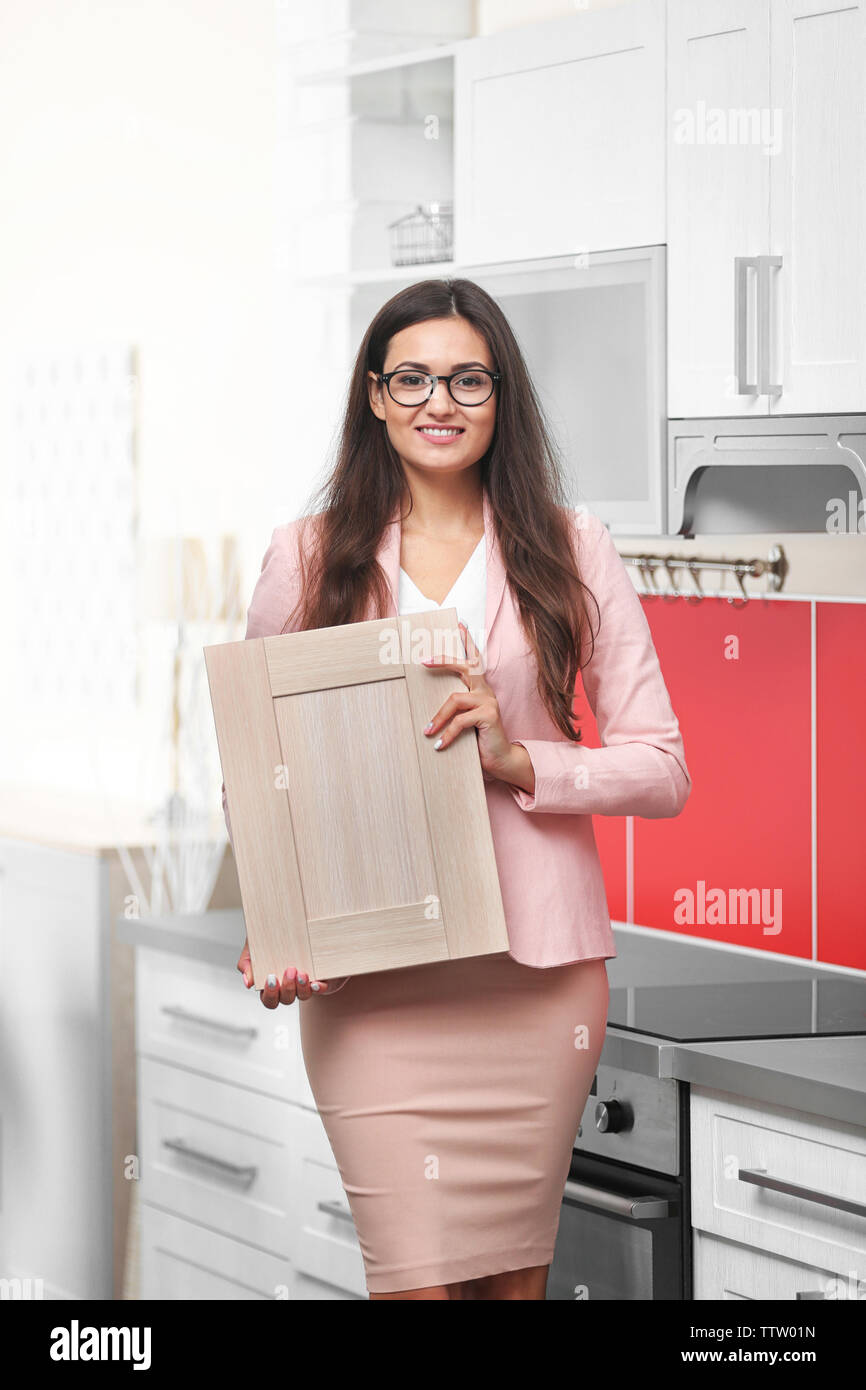 Beautiful female designer with wooden sample in office Stock Photo - Alamy