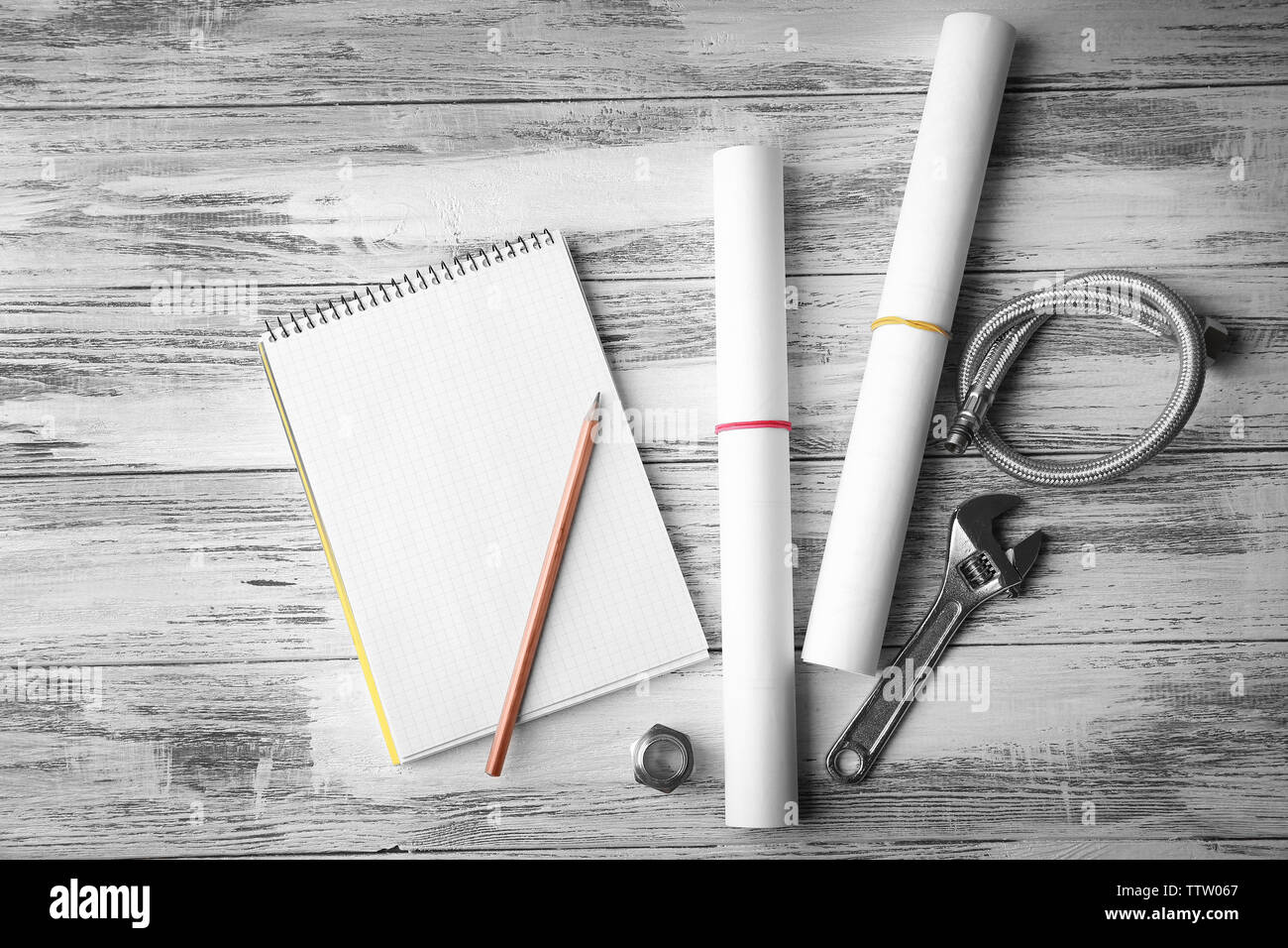 Notebook and plumber tools with blueprints on wooden structure ...