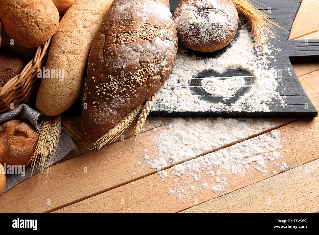 Lots of fresh bread and flour on a board with drawing heart Stock Photo ...