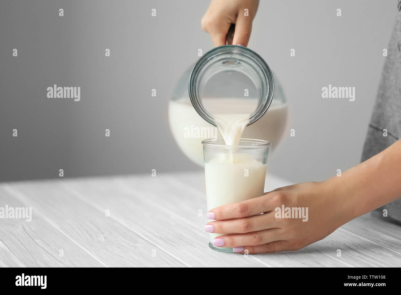 Female hand pouring milk from a jug into a glass Stock Photo - Alamy