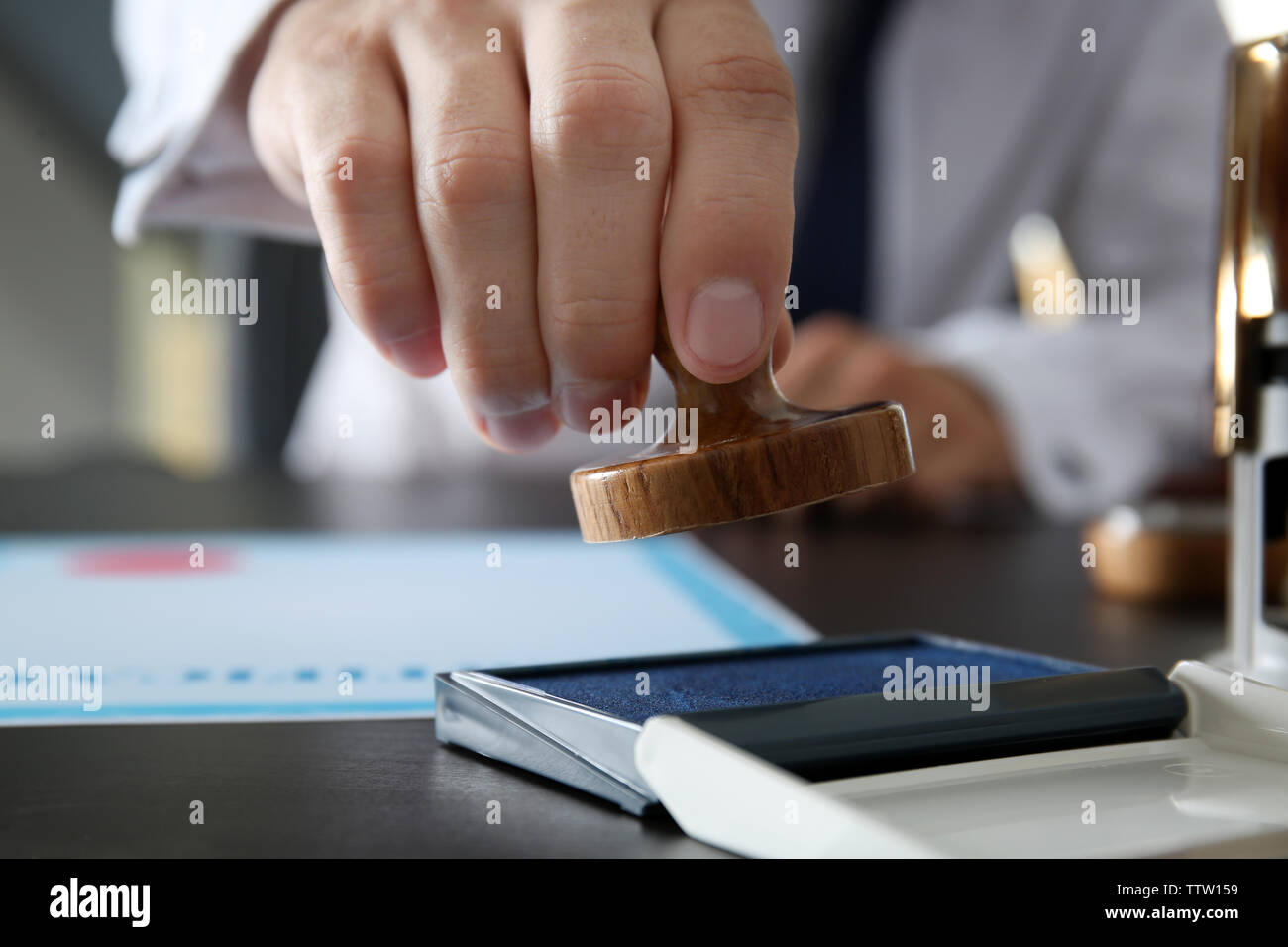 Notary public hand with wooden stamp Stock Photo - Alamy