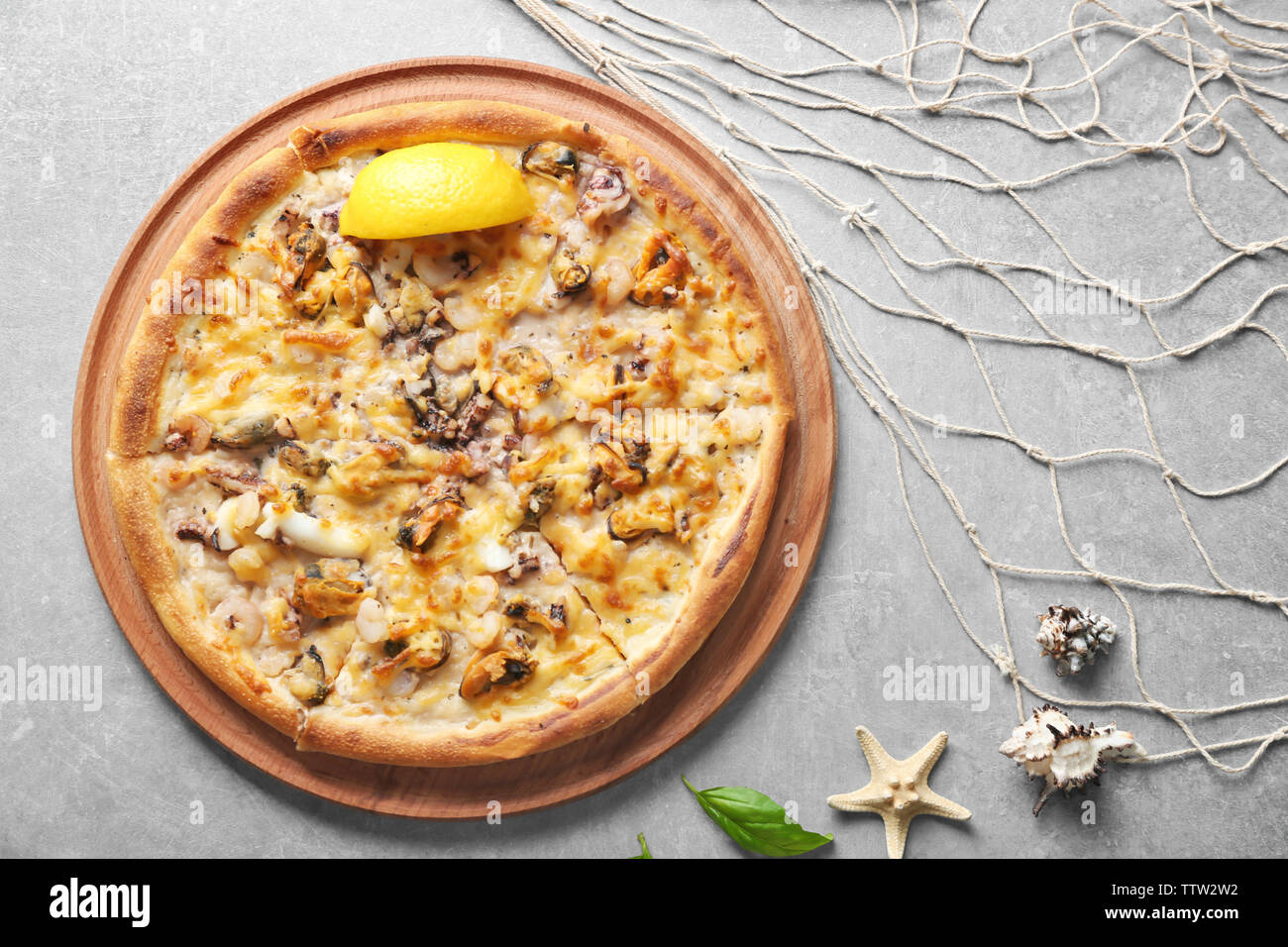 Delicious seafood pizza with starfish and net on grey background Stock ...