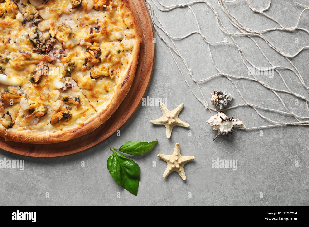 Delicious seafood pizza with starfish and net on grey background Stock ...
