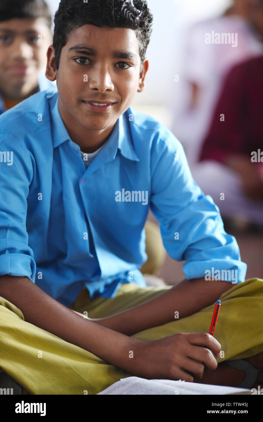 Indian schoolboy reading in a classroom Stock Photo - Alamy