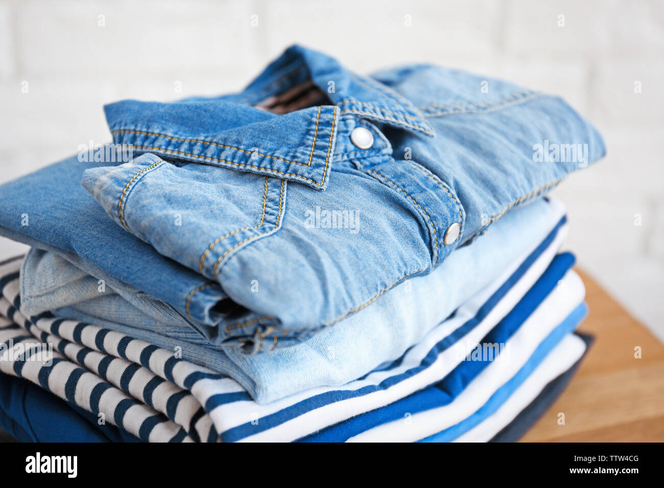Pile of clothes on wooden stool, closeup Stock Photo - Alamy