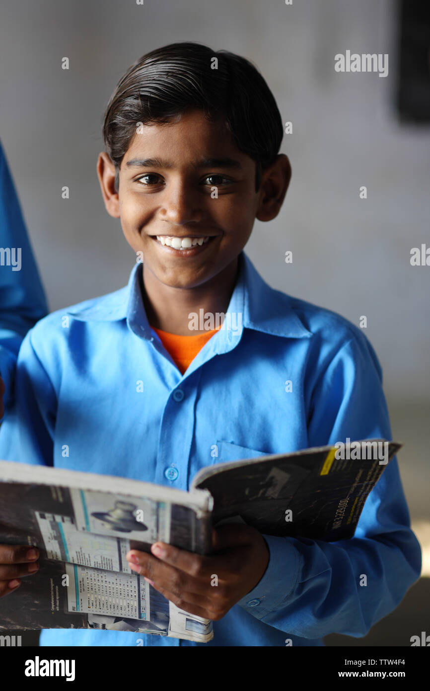 Indian schoolboy reading a book in a classroom Stock Photo - Alamy