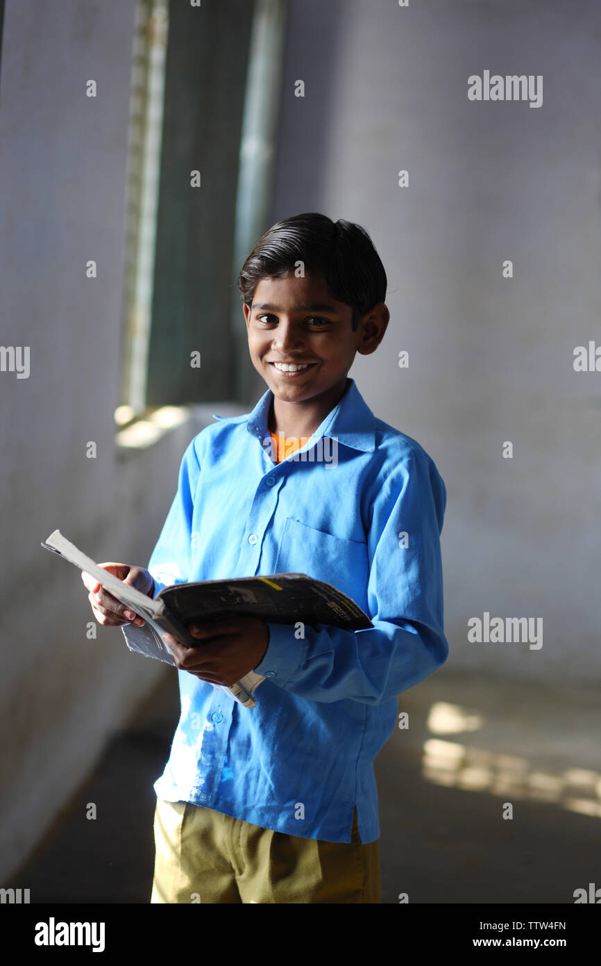 Indian schoolboy reading a book in a classroom Stock Photo - Alamy