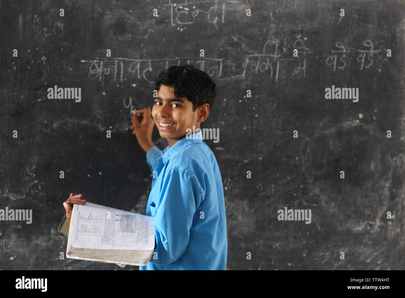 Indian schoolboy writing on blackboard Stock Photo - Alamy