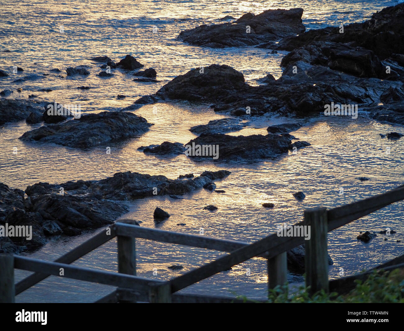 The sparkling sea amongst the rocks at the beach in the shadowing ...