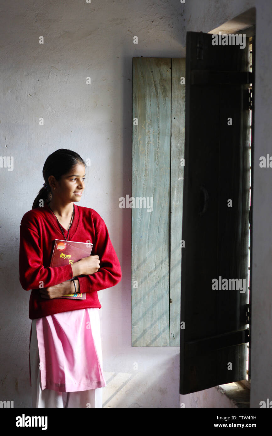 Schoolgirl standing by a window in a classroom Stock Photo - Alamy