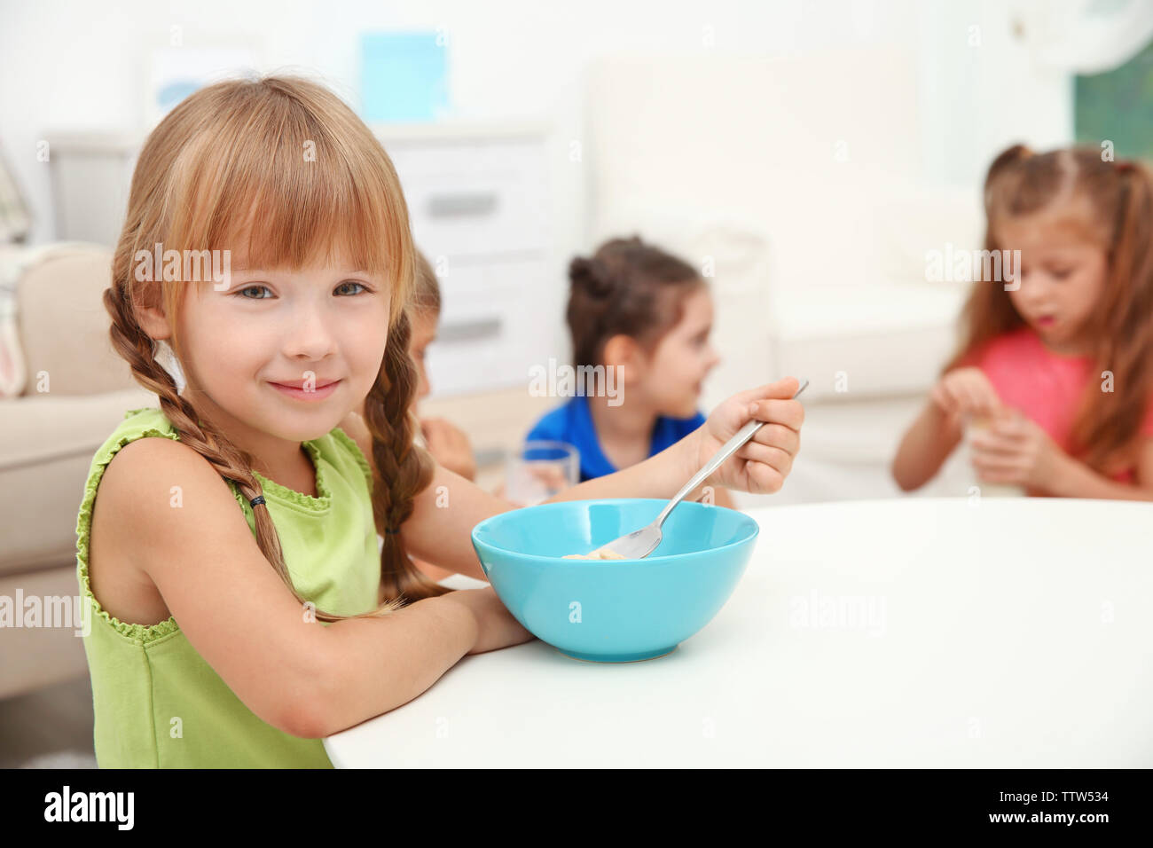 Portrait of little girl eating cornflakes with milk Stock Photo - Alamy