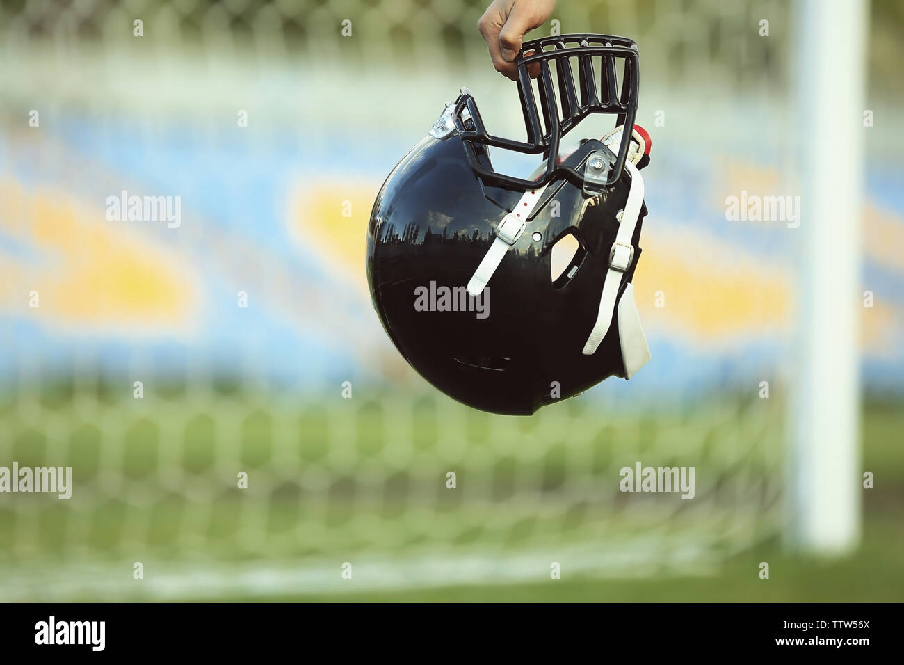 Male hand holding rugby helmet Stock Photo - Alamy
