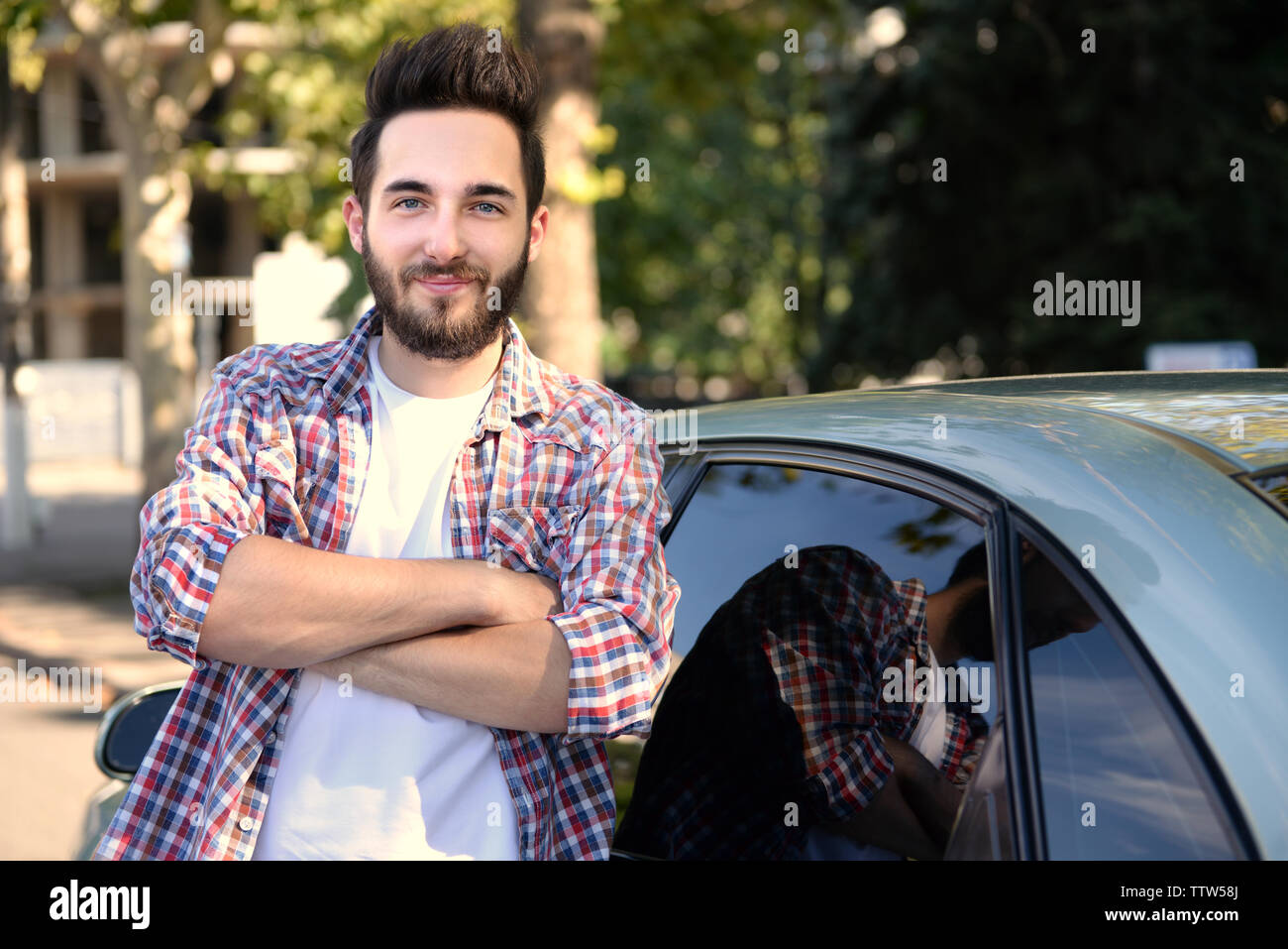 Successful young man standing near car Stock Photo - Alamy