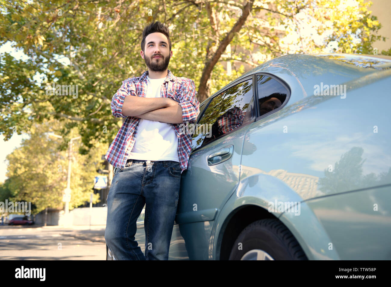 Successful young man standing near car Stock Photo - Alamy