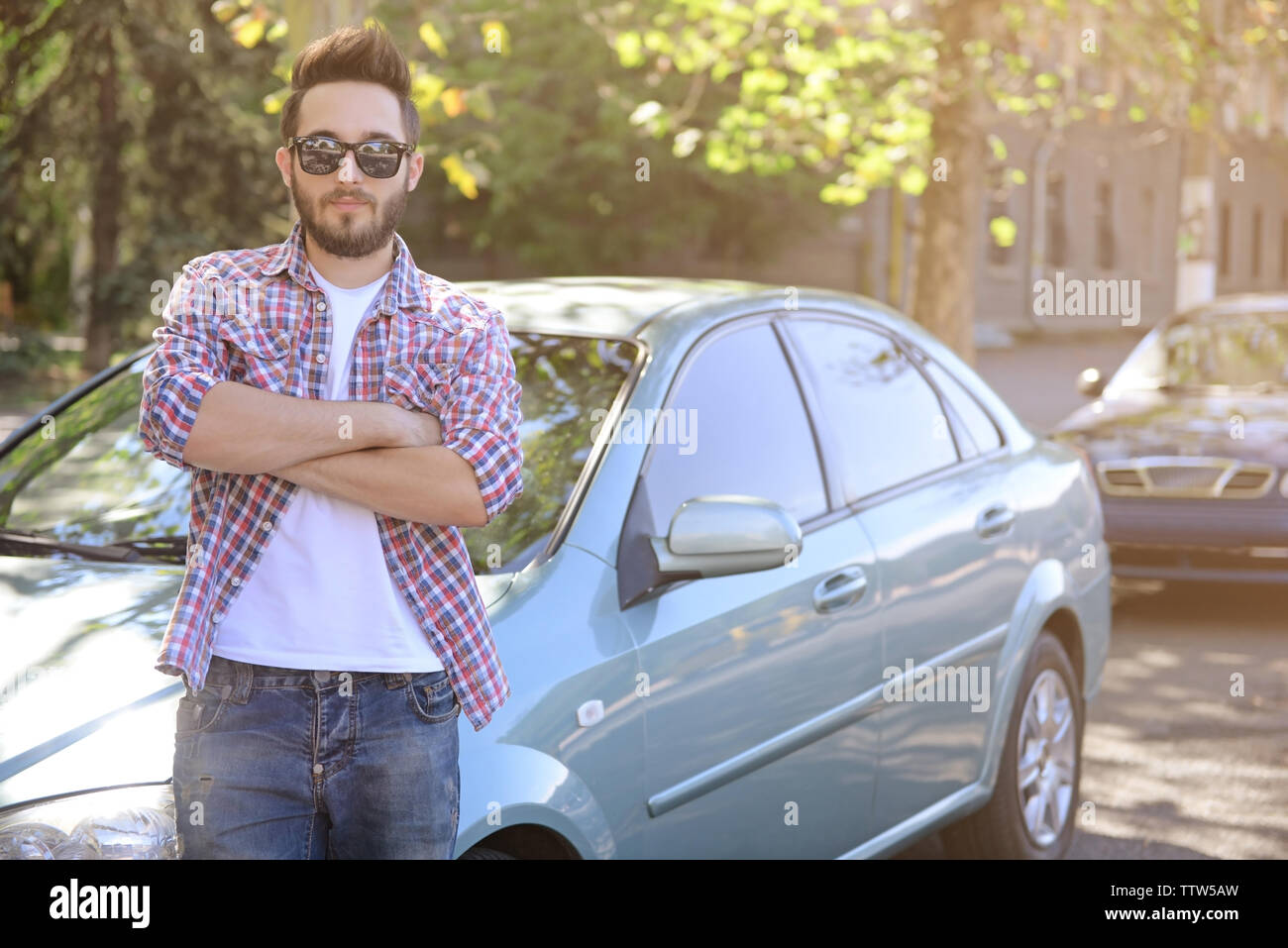 Successful young man standing near car Stock Photo - Alamy