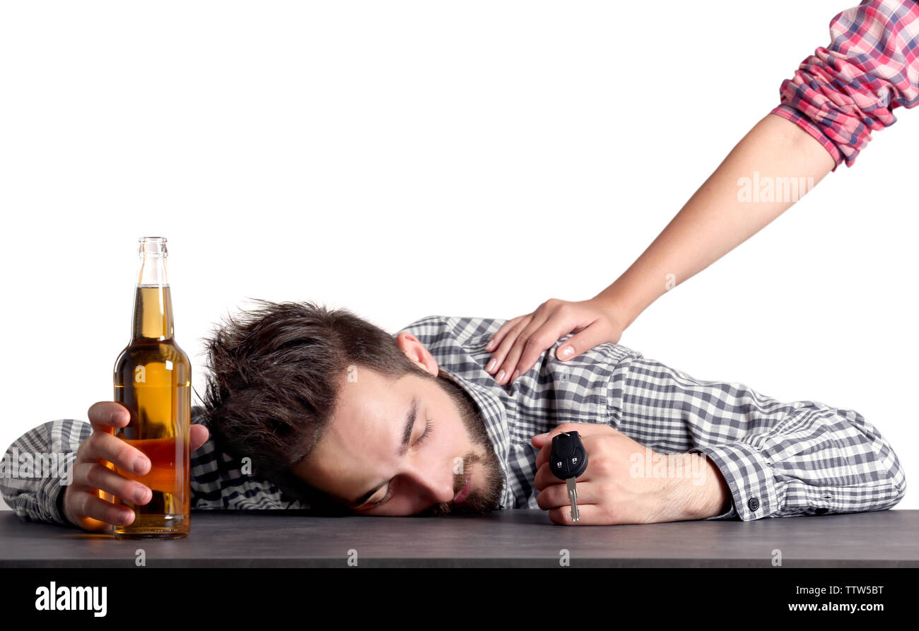 Young drunk man with car key and bottle of beer on grey background ...