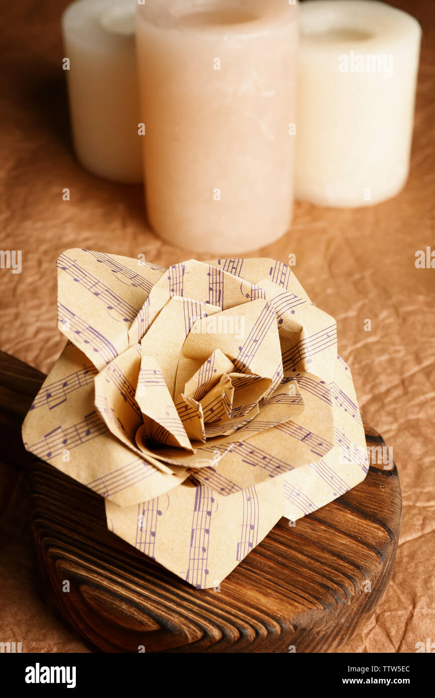 Beautiful rose made of music notes with candles on textured paper ...
