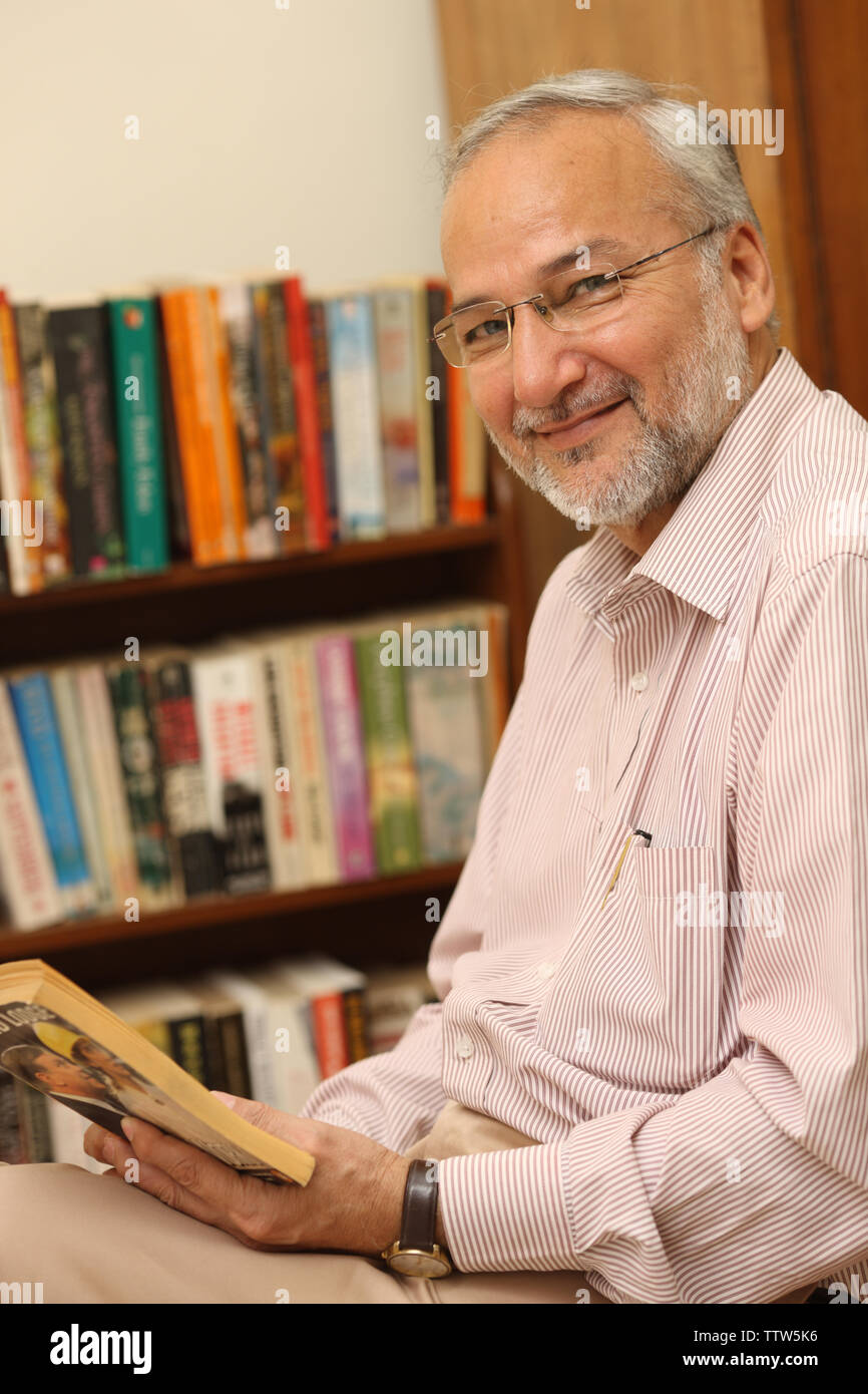 Indian old man reading a book Stock Photo - Alamy