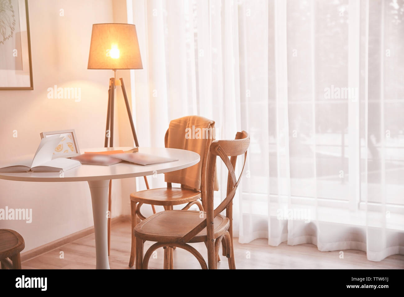 Table with chairs in light room interior Stock Photo - Alamy