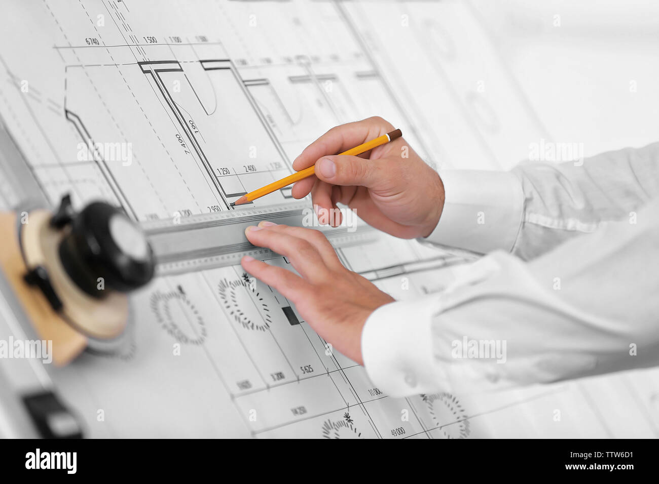 Young creative male engineer making project on drawing board, closeup ...