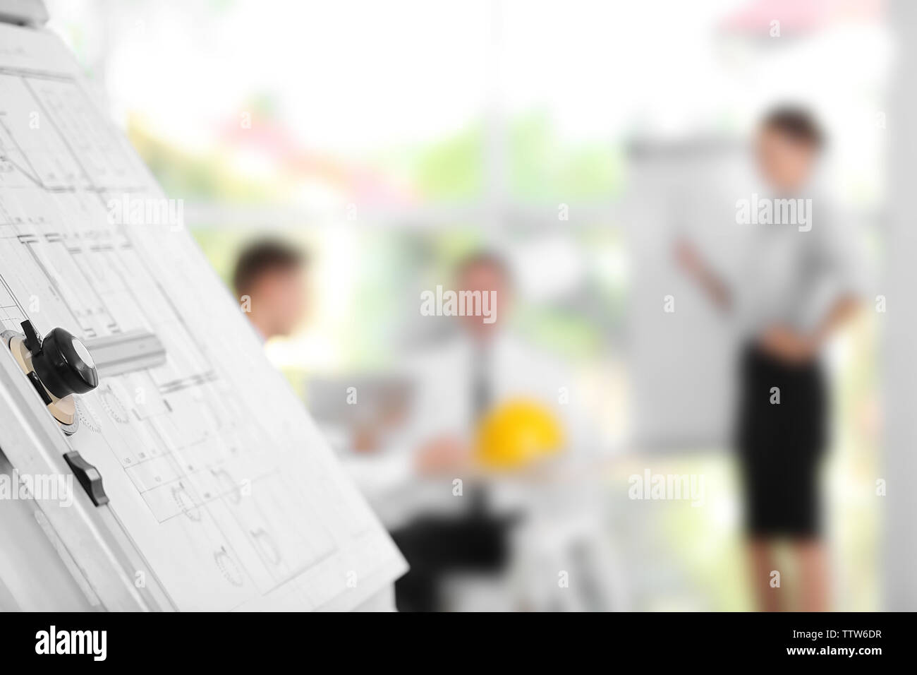 Drawing board with architectural project and engineers on blurred ...