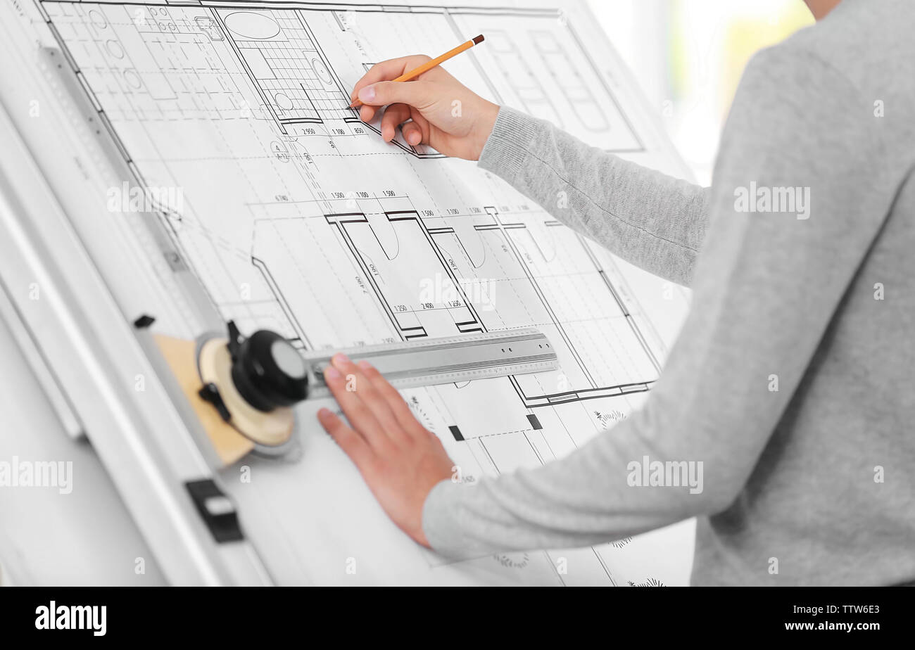 Young creative male engineer working with new project on drawing board ...