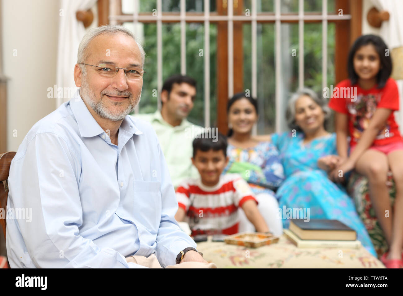 Portrait of a man with his family in the background Stock Photo - Alamy