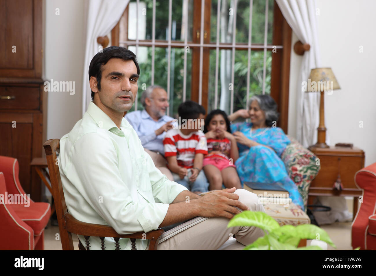 Portrait of a man with his family in the background Stock Photo - Alamy