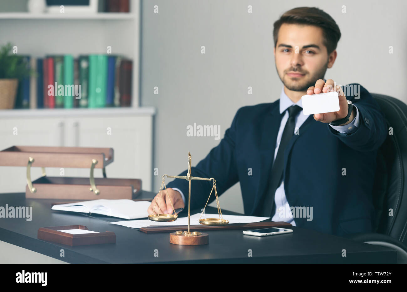 Handsome young man giving business card in modern office Stock Photo ...